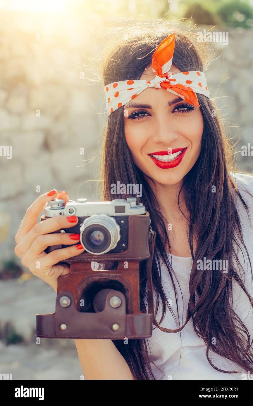 Beautiful woman taking photo with old fashioned film camera. Close up ...