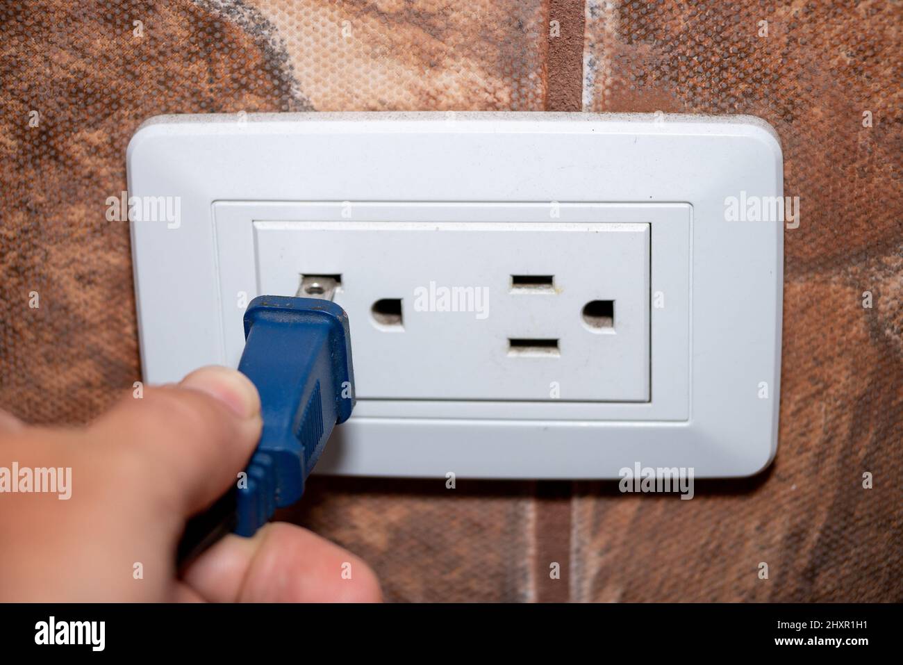 Hand pulling electrical plug from household power outlet isolated Stock ...