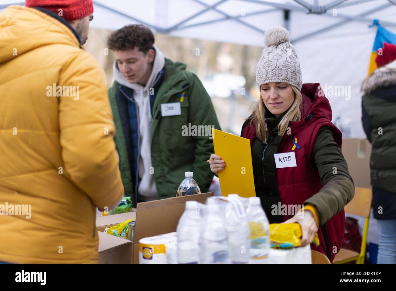 Volunteers distributing food and drink to refugees on the Ukrainian ...