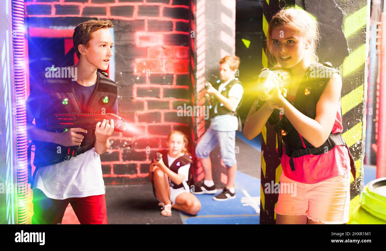 Girls and boys playing laser tag Stock Photo - Alamy