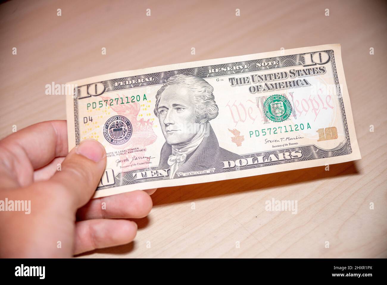 Hand holding 10 dollar banknote hi-res stock photography and images - Alamy