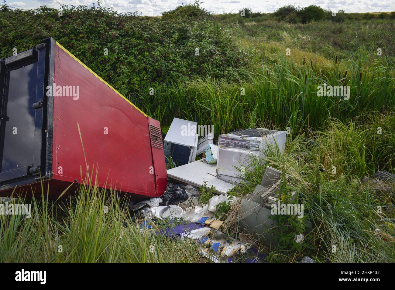 Fly-tipped garbage in drainage ditch Stock Photo - Alamy