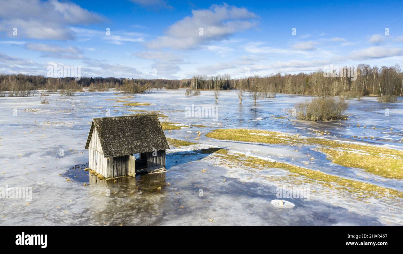 Water covered spring time floodplain with traditional hay barn in ...