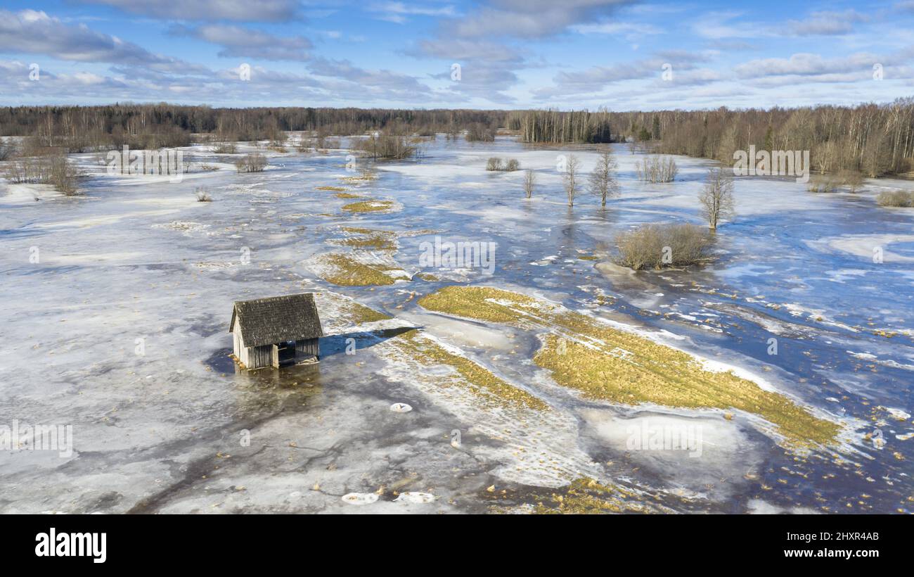Water covered spring time floodplain with traditional hay barn in ...