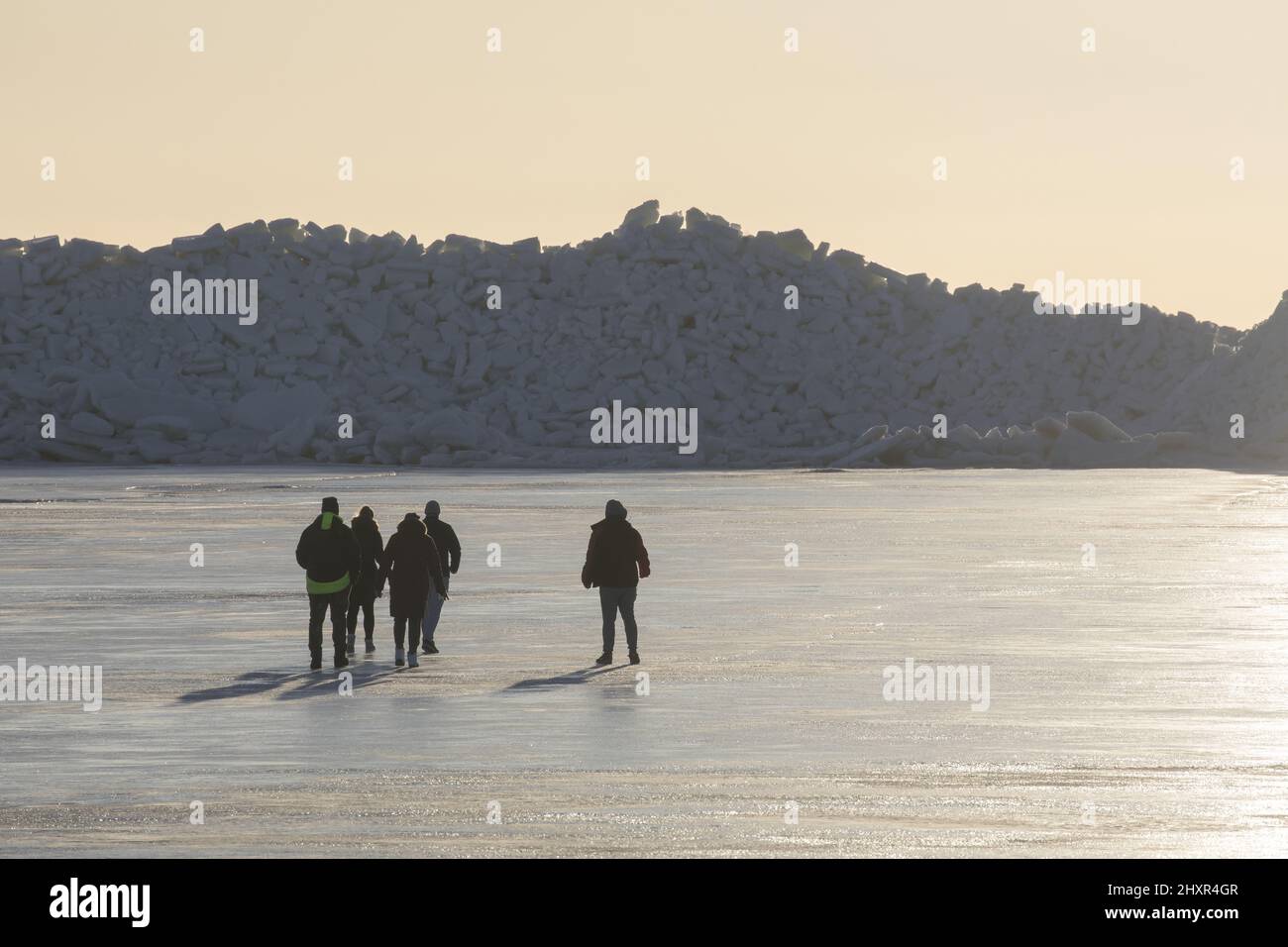 People walking over ice toward ice piles Stock Photo - Alamy