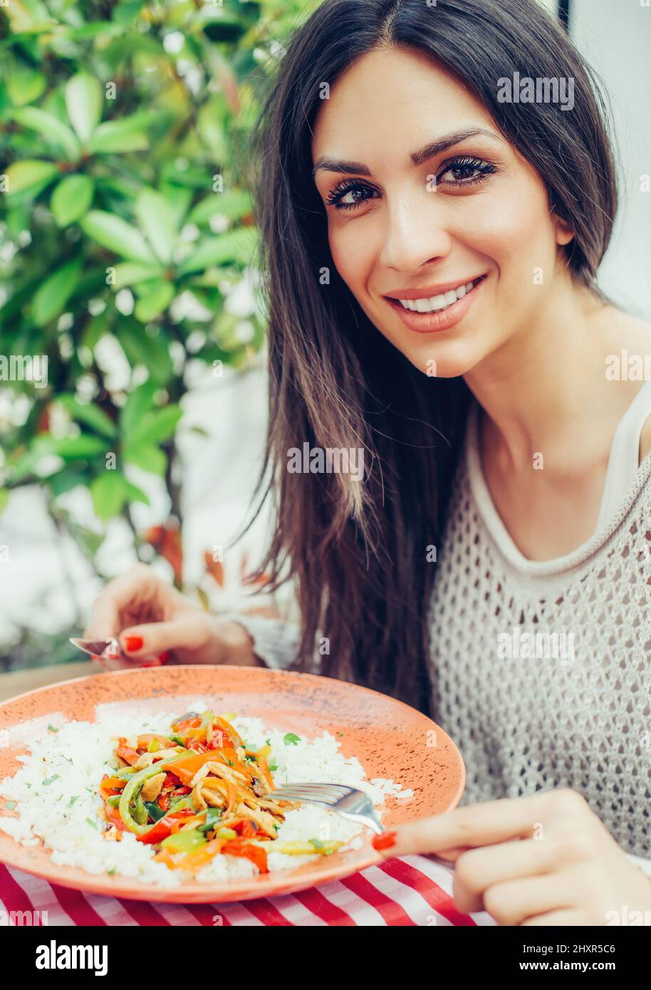 Young woman eating chinese food in a restaurant, having her lunch break ...