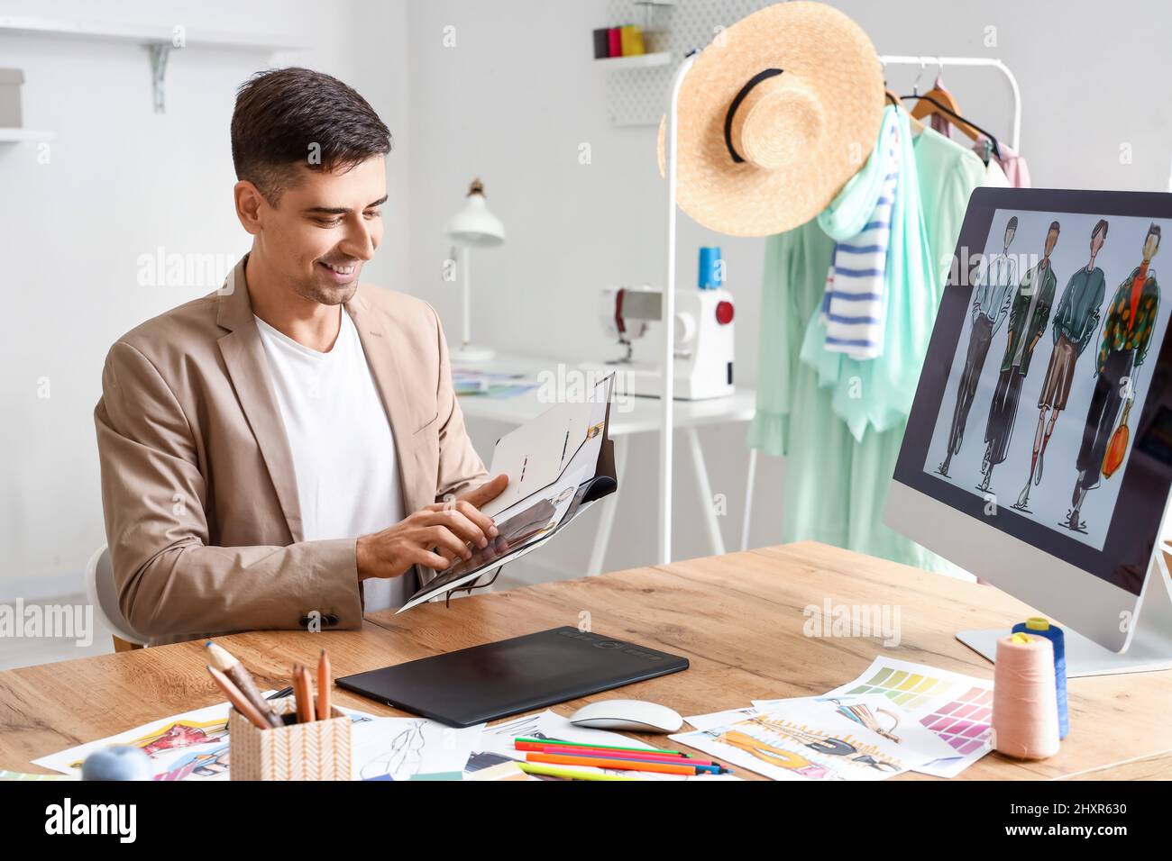 Male fashion designer working in studio Stock Photo - Alamy