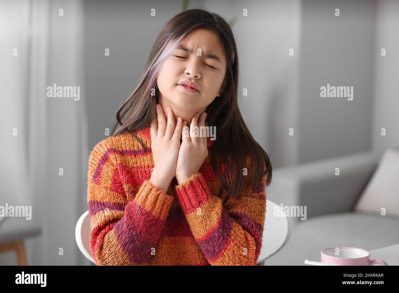 Ill Asian girl with sore throat at home Stock Photo - Alamy