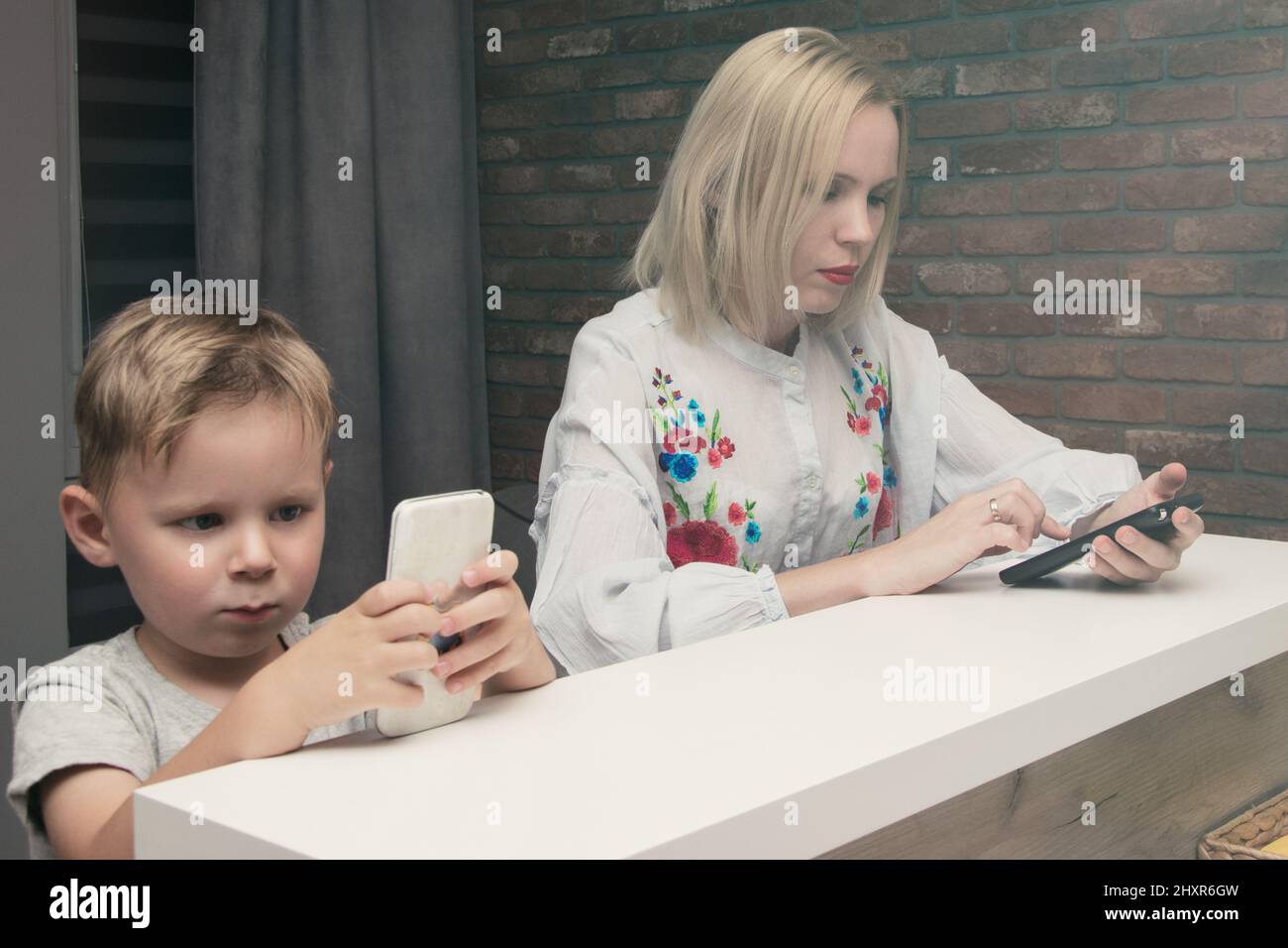 Mother and child with mobile phones. The concept of dependence on the ...