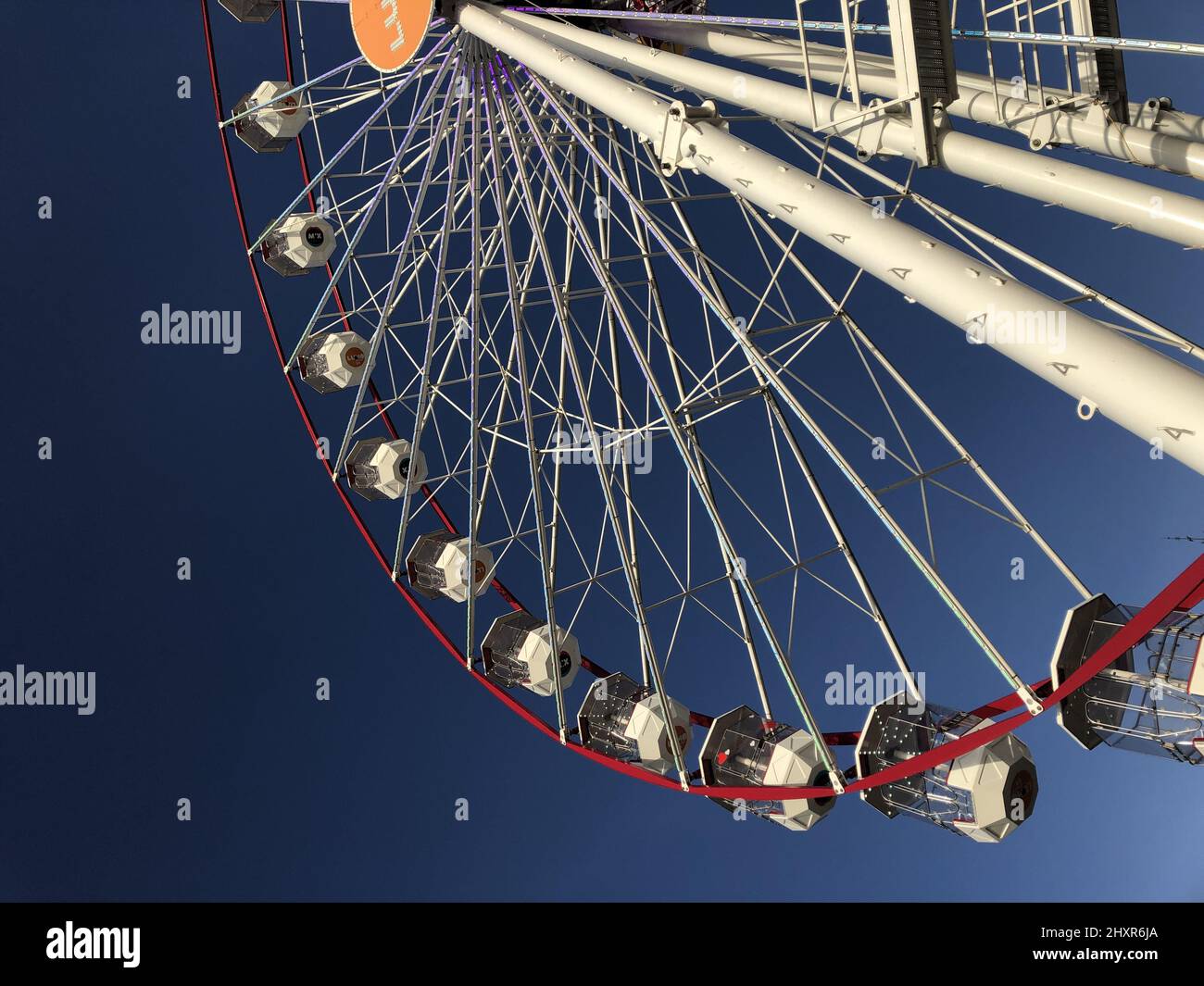section of a giant ferris wheel from below with blue sky, unique ...