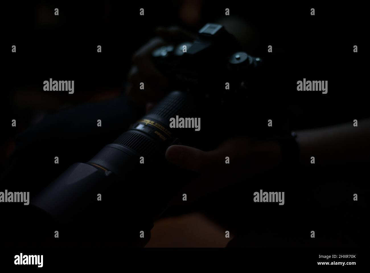 Photographer adjusting the focus of a camera Stock Photo - Alamy