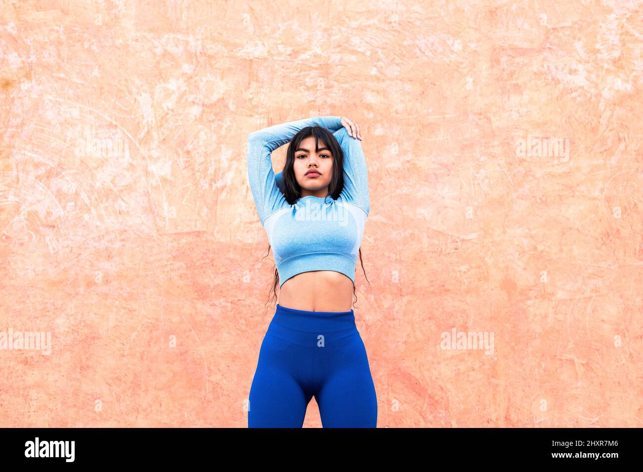 Attractive Colombian woman dressed in sportswear stretching her muscles ...