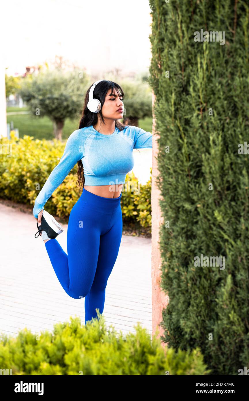 Attractive Colombian woman dressed in sportswear stretching her muscles ...