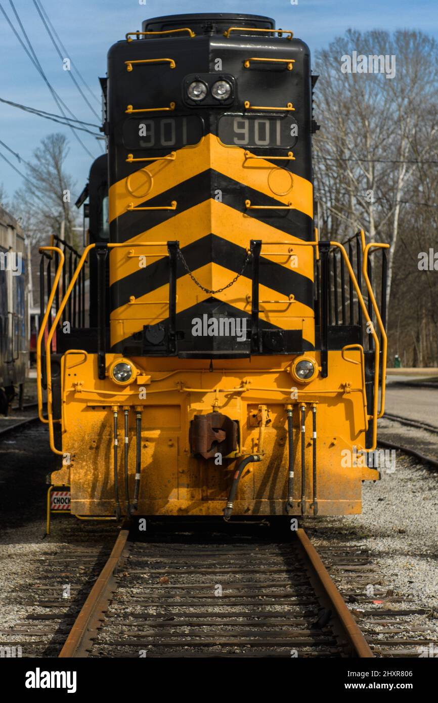 Old rusty train locomotive with yellow signs on its front in the park ...