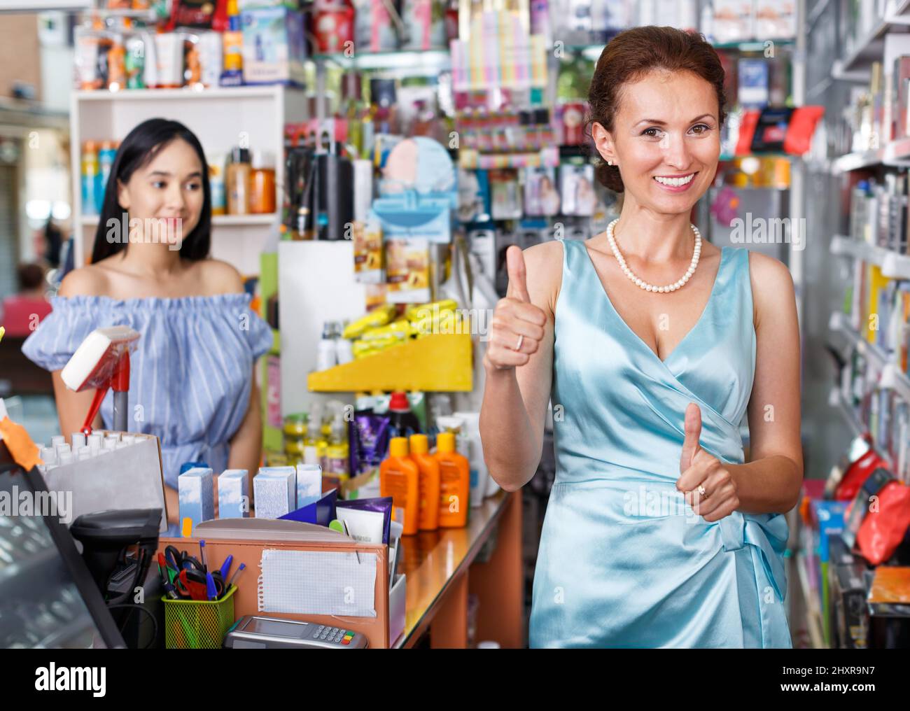 Saleswoman helping to client with payments in salon Stock Photo - Alamy