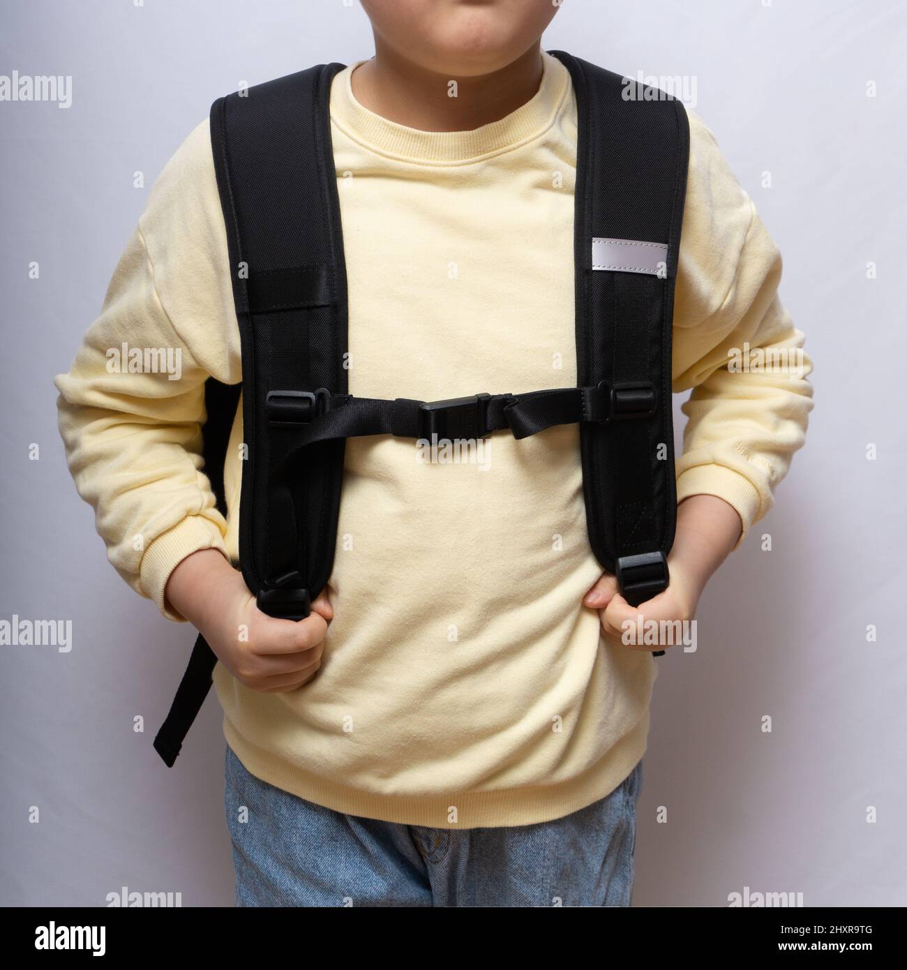 Asian child standing with a black backpack Stock Photo - Alamy