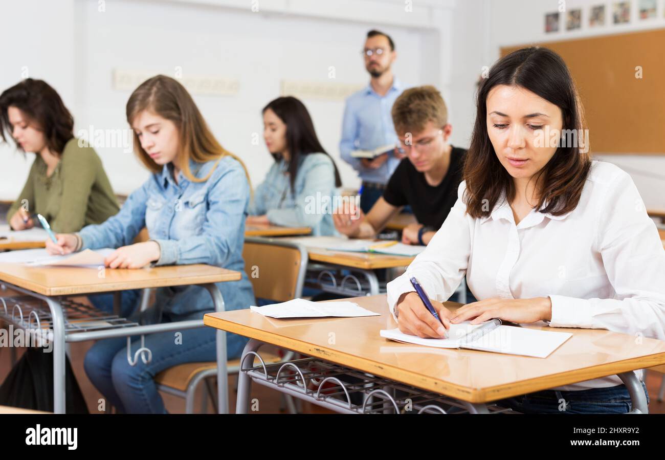 Girl writing test in classroom Stock Photo - Alamy
