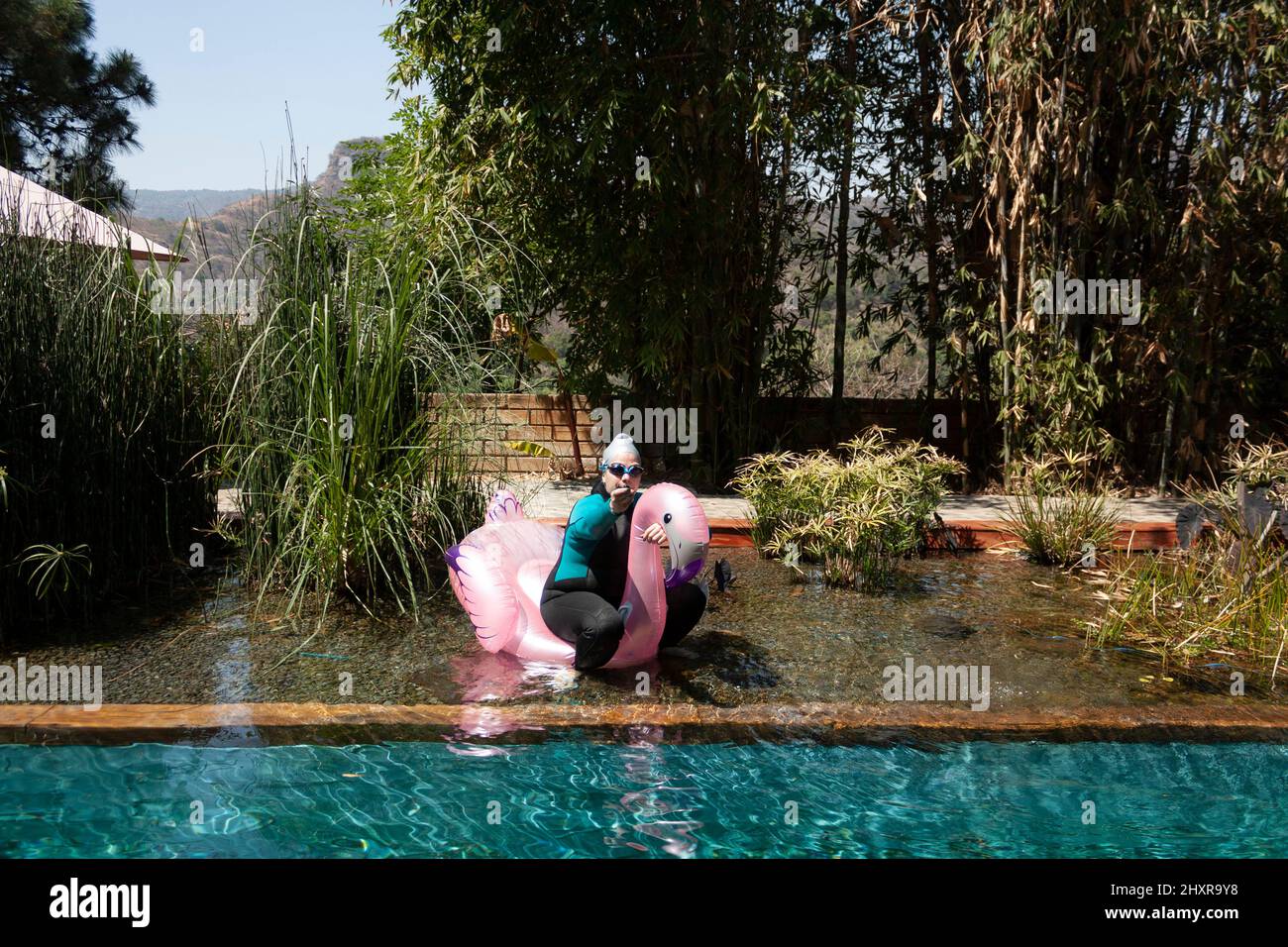Caucasian Mexican woman plays in safety area and splashes with an ...