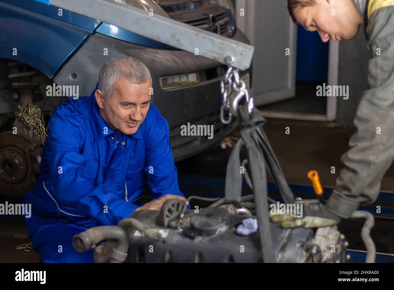 Photo of diesel engine. An experienced mechanic and his colleague ...