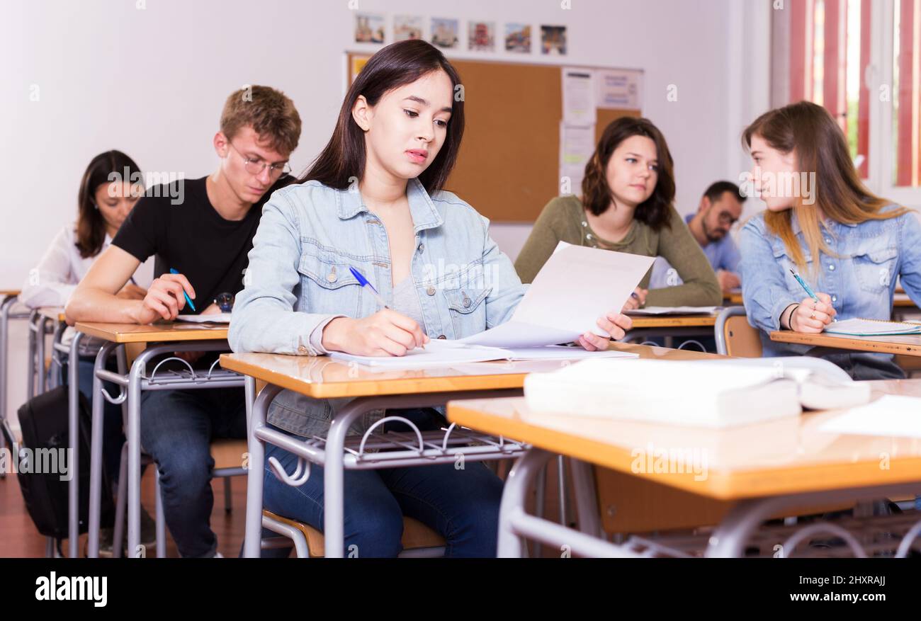 Girl writing test in classroom Stock Photo - Alamy