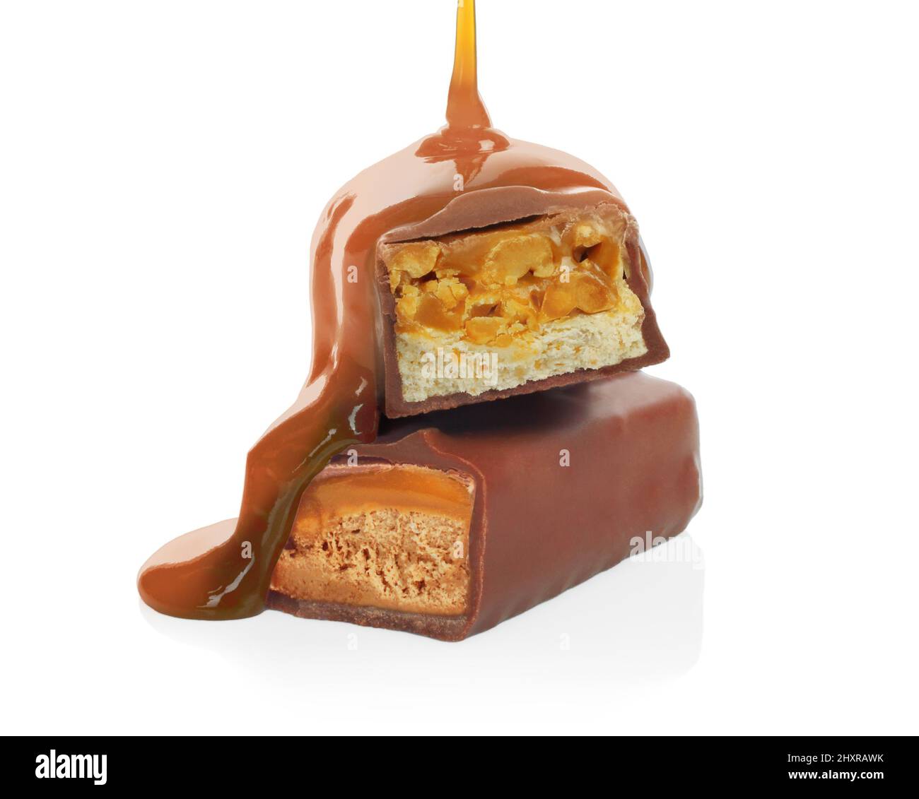 Pouring caramel on broken chocolate bars on white background close-up ...
