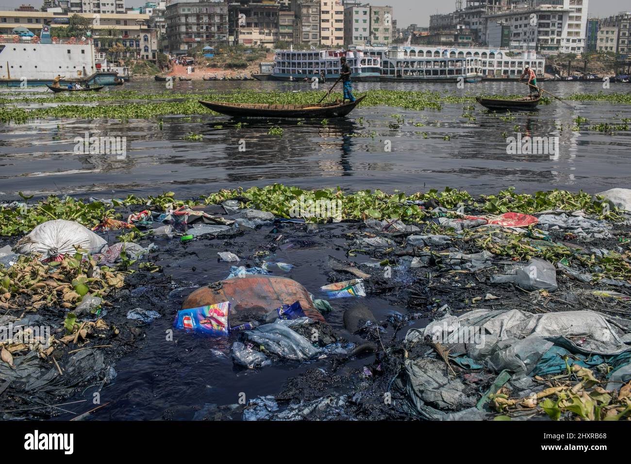 Dhaka, Bangladesh. 13th Mar, 2022. People cross on a boat over the pitch-black water of the ...
