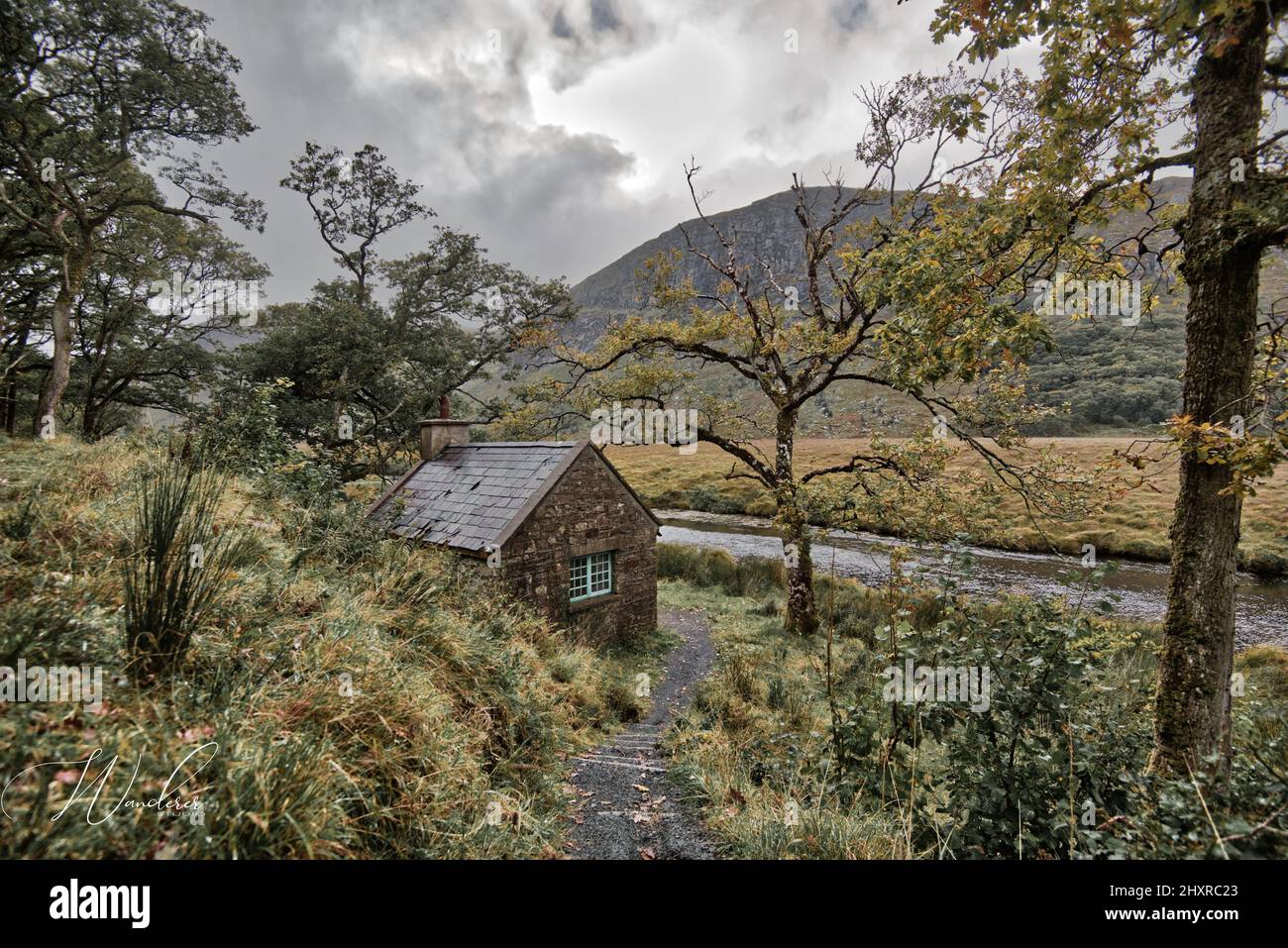 Lonely small hut near the river and trees in Donegal, Republic of ...