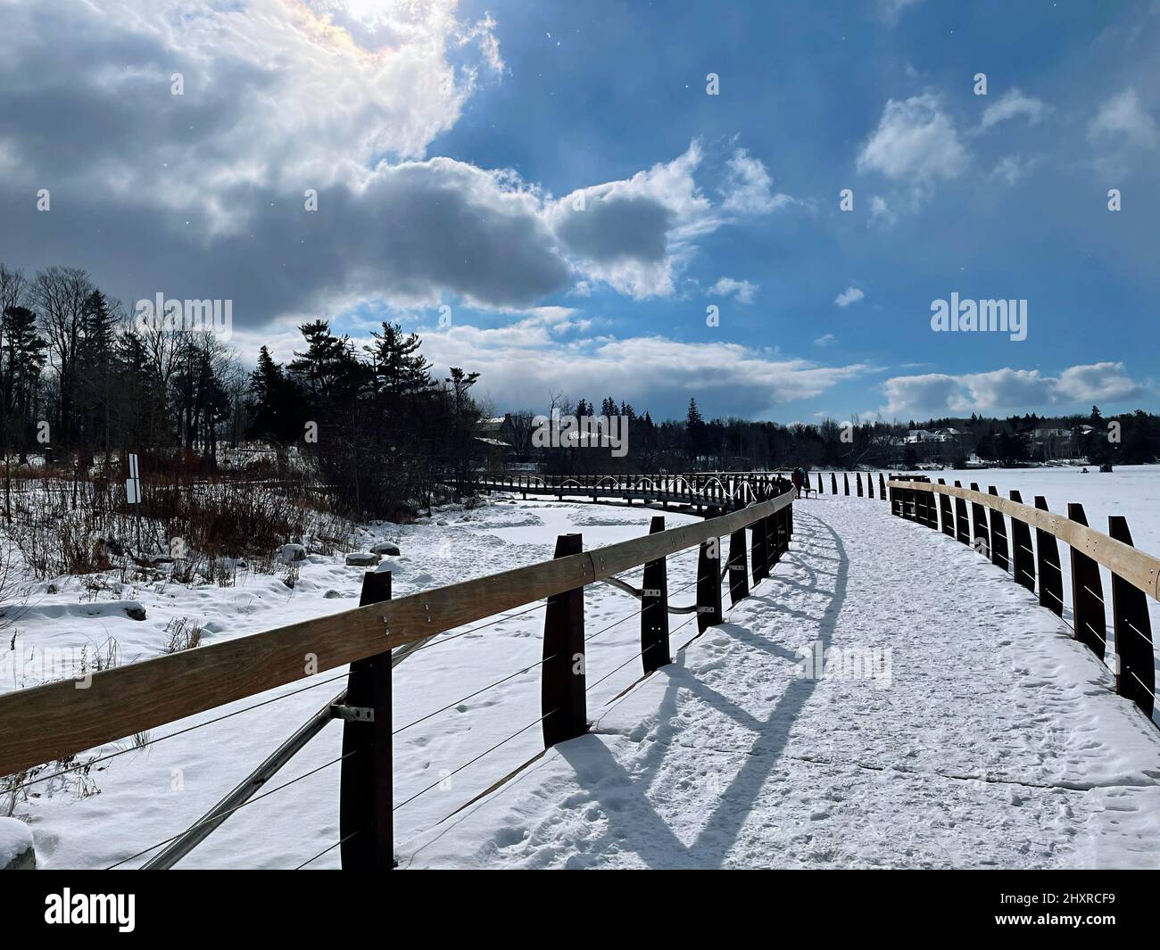 Snowy path with wooden handrails from both sides Stock Photo - Alamy