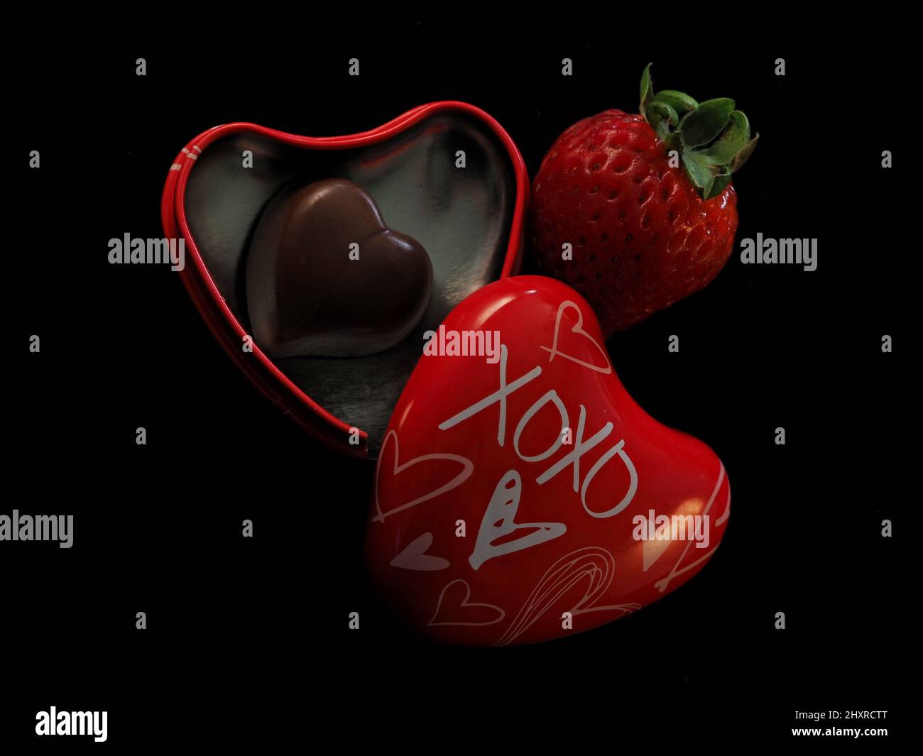 Closeup of Xoxo Heart chocolate fresa roja isolated on black background ...