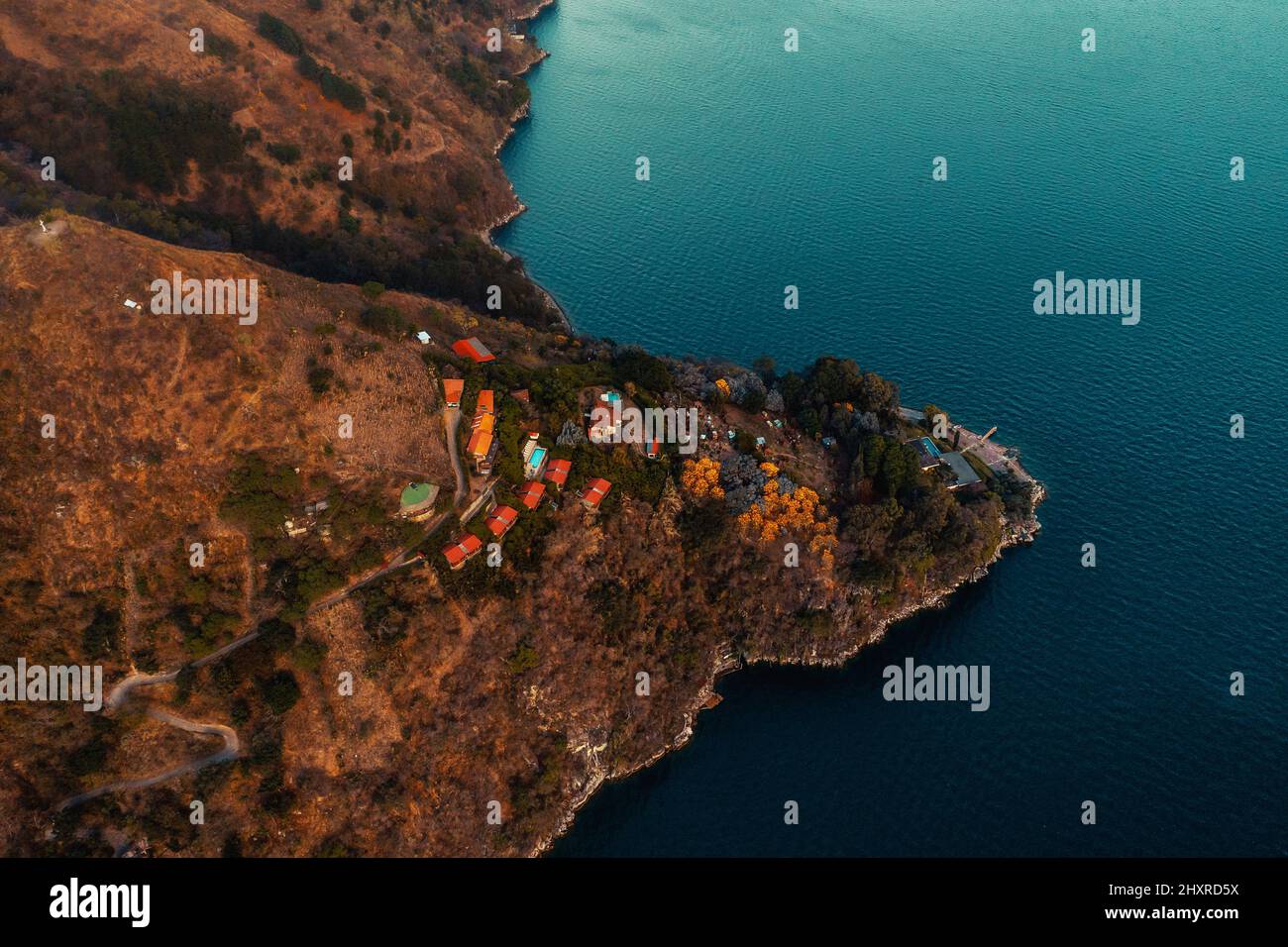 Bird's eye view of houses on the rocky shore of blue Lake Atitlan in ...