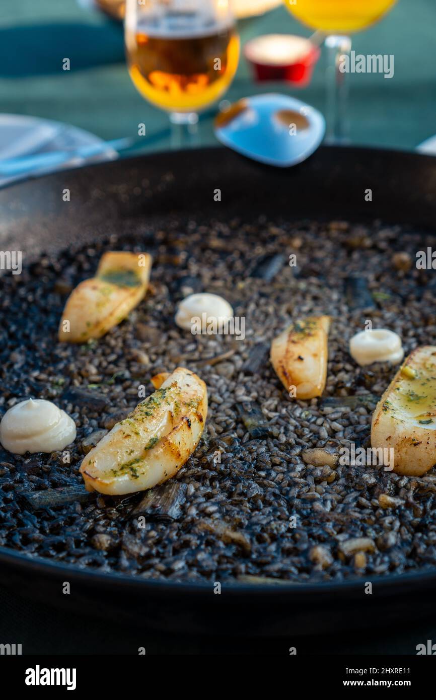 Closeup of Black rice with cuttlefish and young garlic in Spain Stock ...