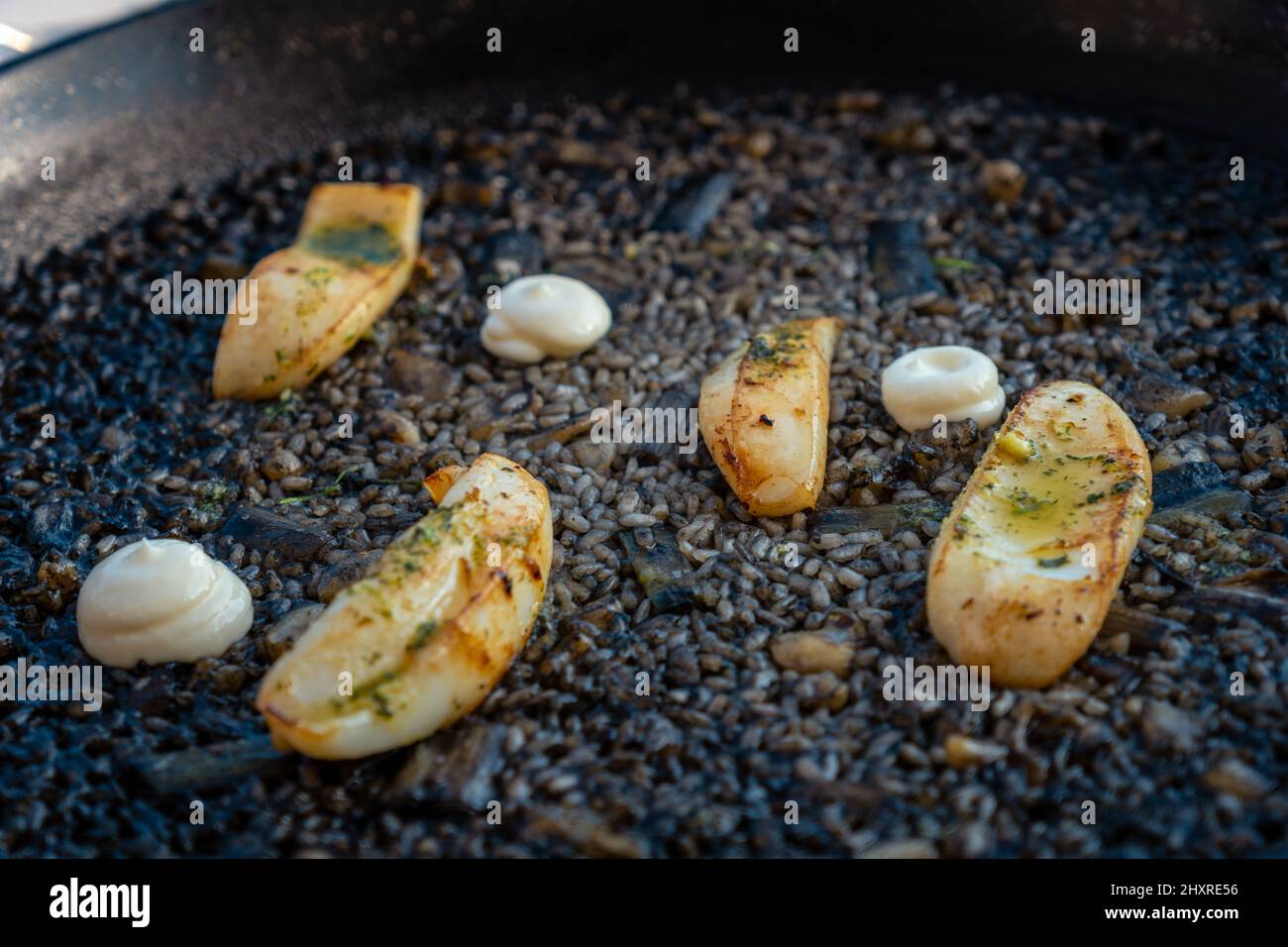 Closeup shot of black rice with cuttlefish and young garlic cooked in ...