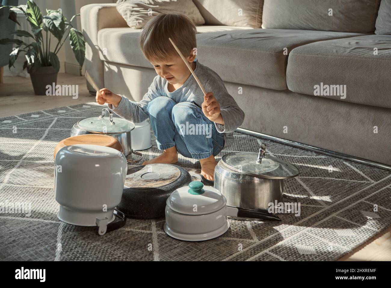 Child drummer having fun drum playing on kitchen pans at home Stock ...