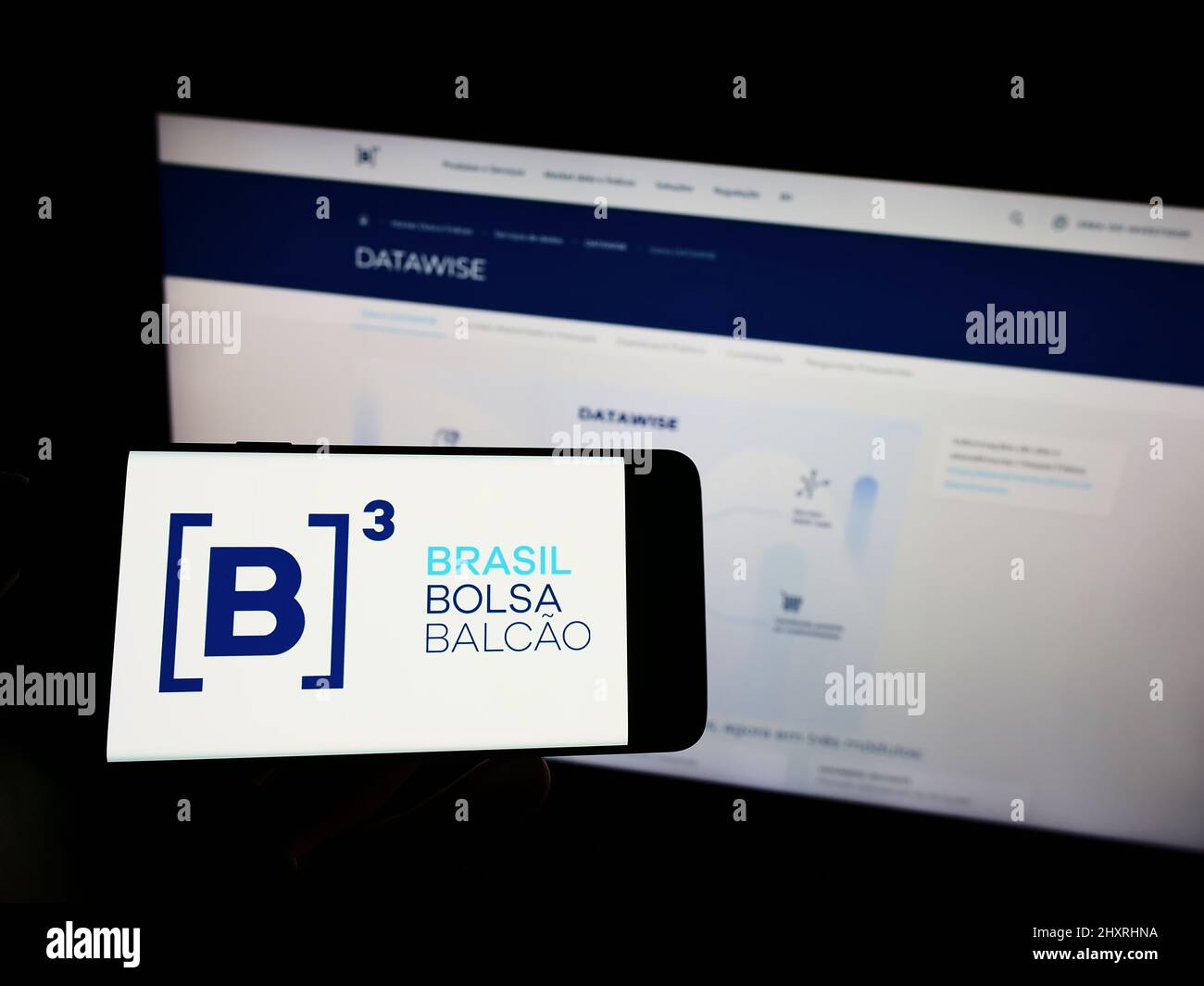 Person holding mobile phone with logo of company B3 SA - Brasil, Bolsa ...