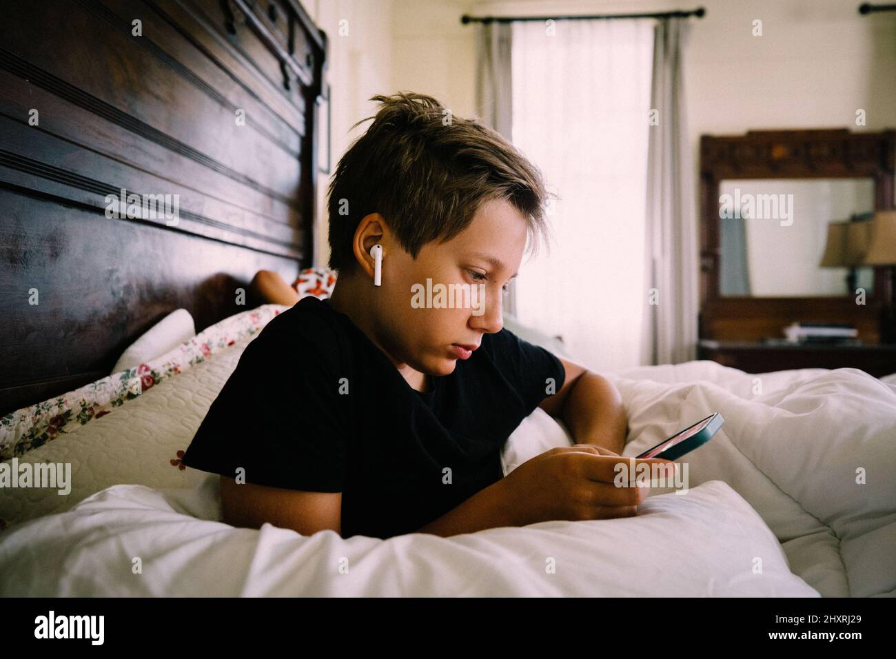 Child with headphones and iphone hi-res stock photography and images ...
