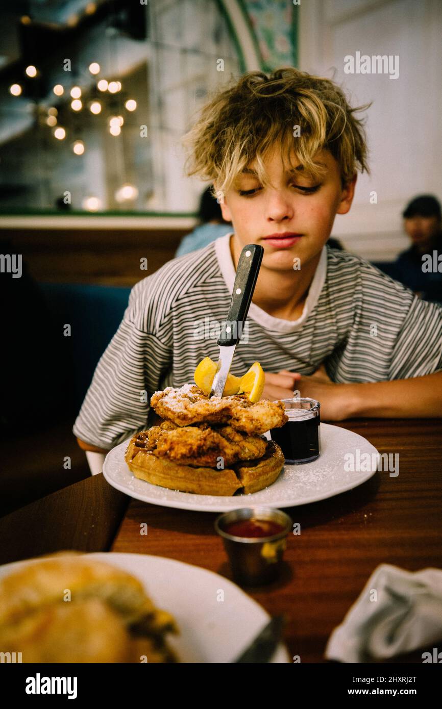 Teen Boy Looks at his Giant Breakfast of Fried Chicken and Waffles ...