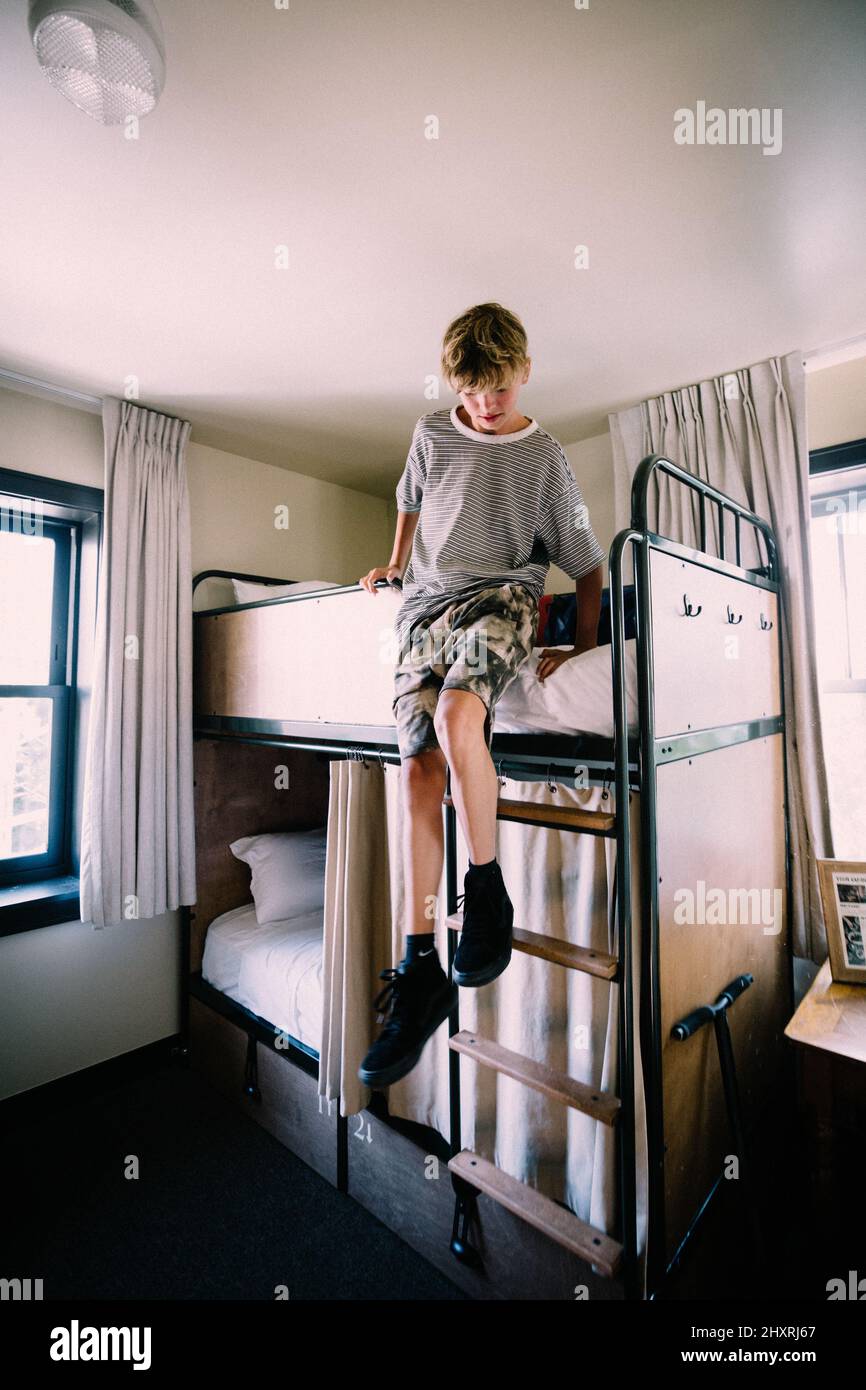 Teen Boy Slides down From Bunkbed in Hostel Stock Photo - Alamy