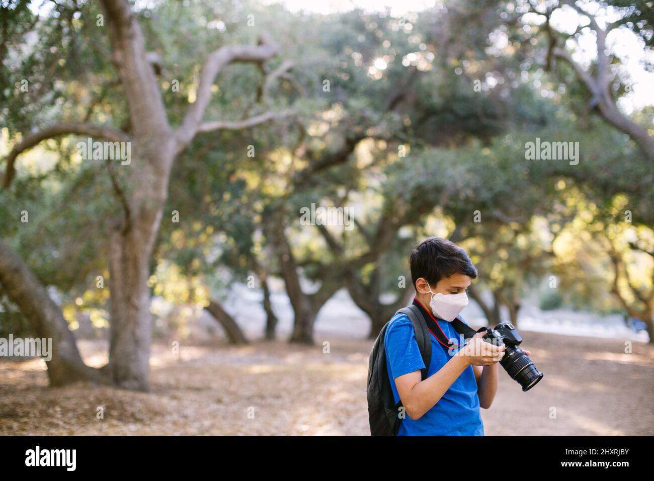 Boy Looking At The Back Of his Camera While Out In Nature Stock Photo ...