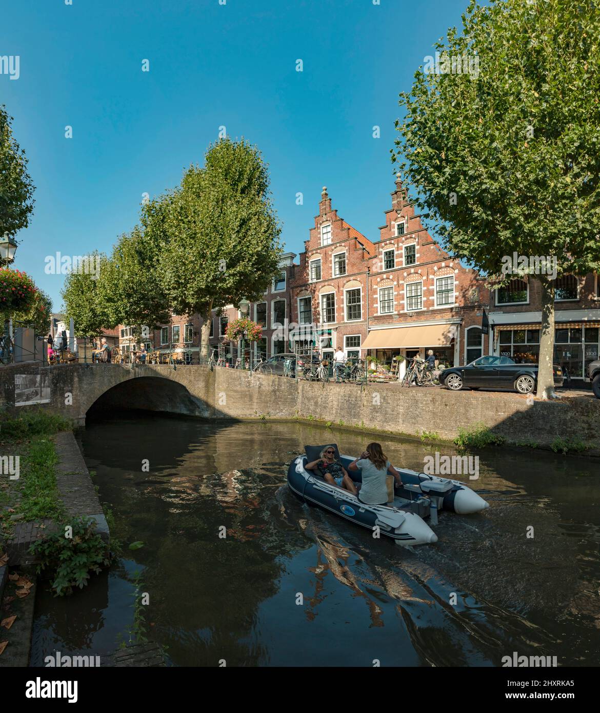 Boating at a canal, step-gabled houses, Oudewater, Utrecht, Netherlands ...