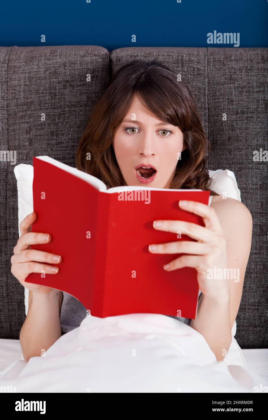 Girl looking surprised reading book hi-res stock photography and images ...