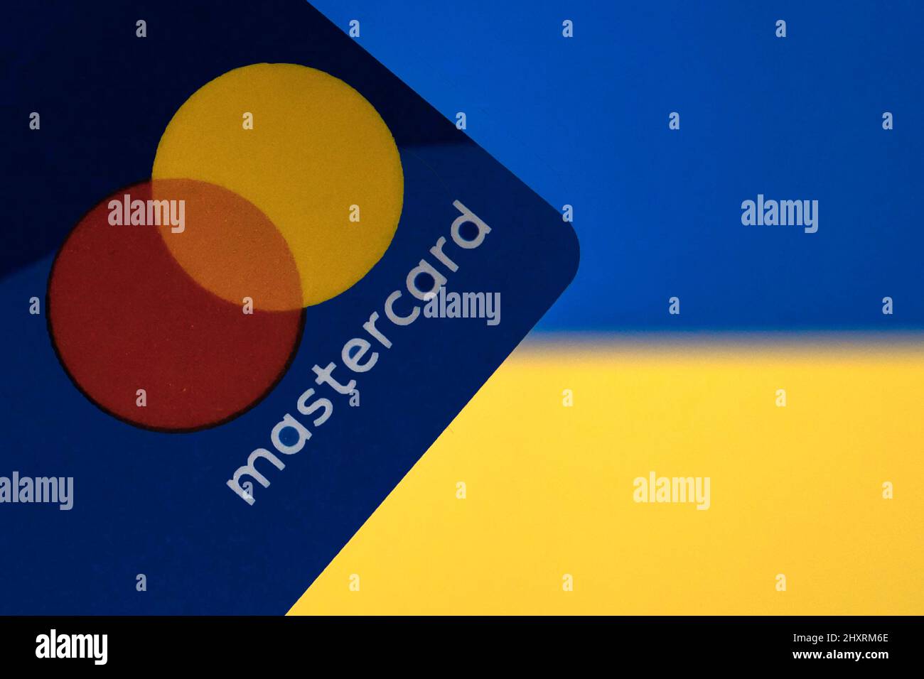 In this photo illustration a Mastercard logo seen with a flag of the ...