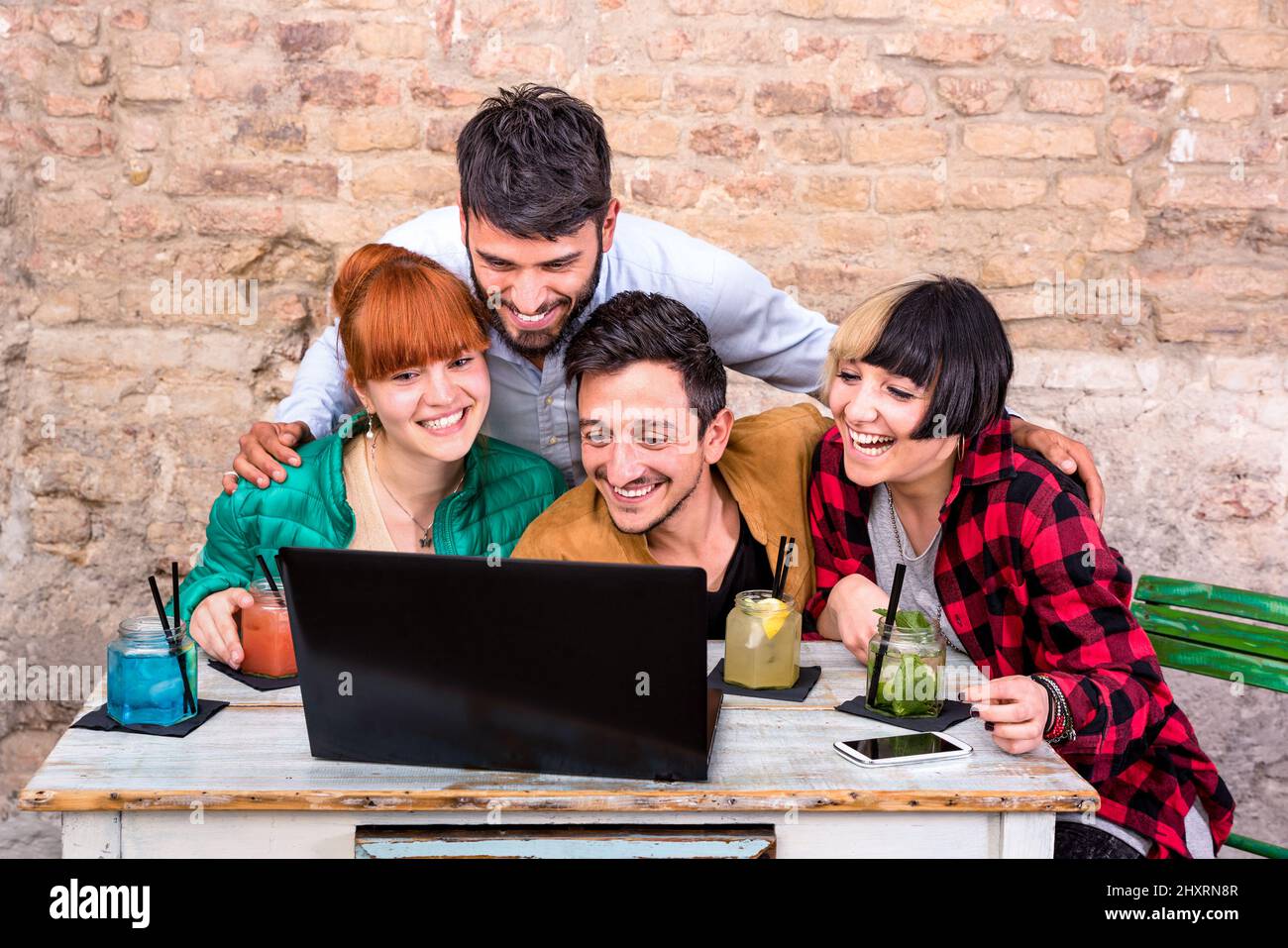 Group of young hipster best friends with computer in urban alternative ...