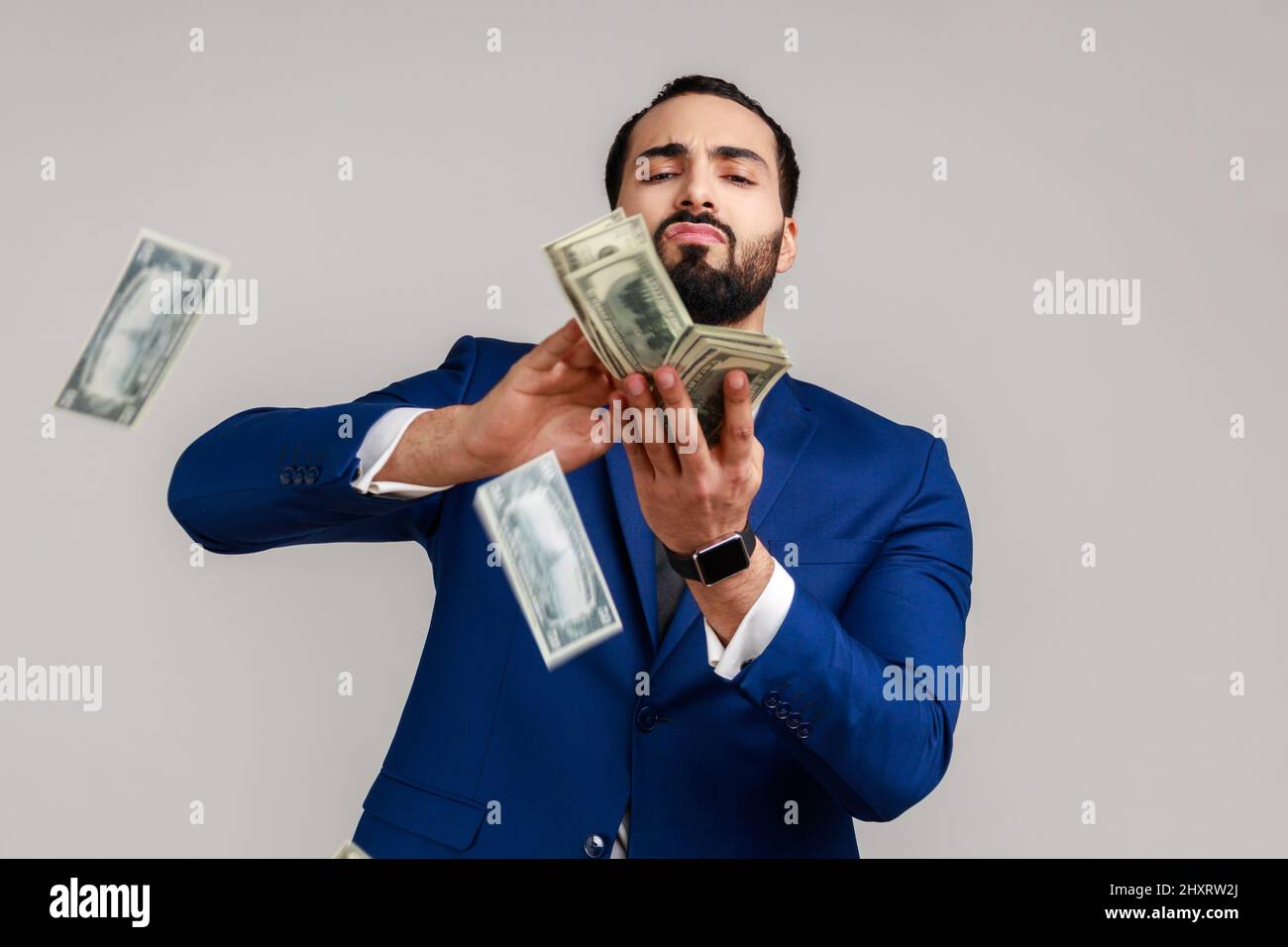 Bearded man scattering dollars with arrogant grimace, boasting wealthy ...