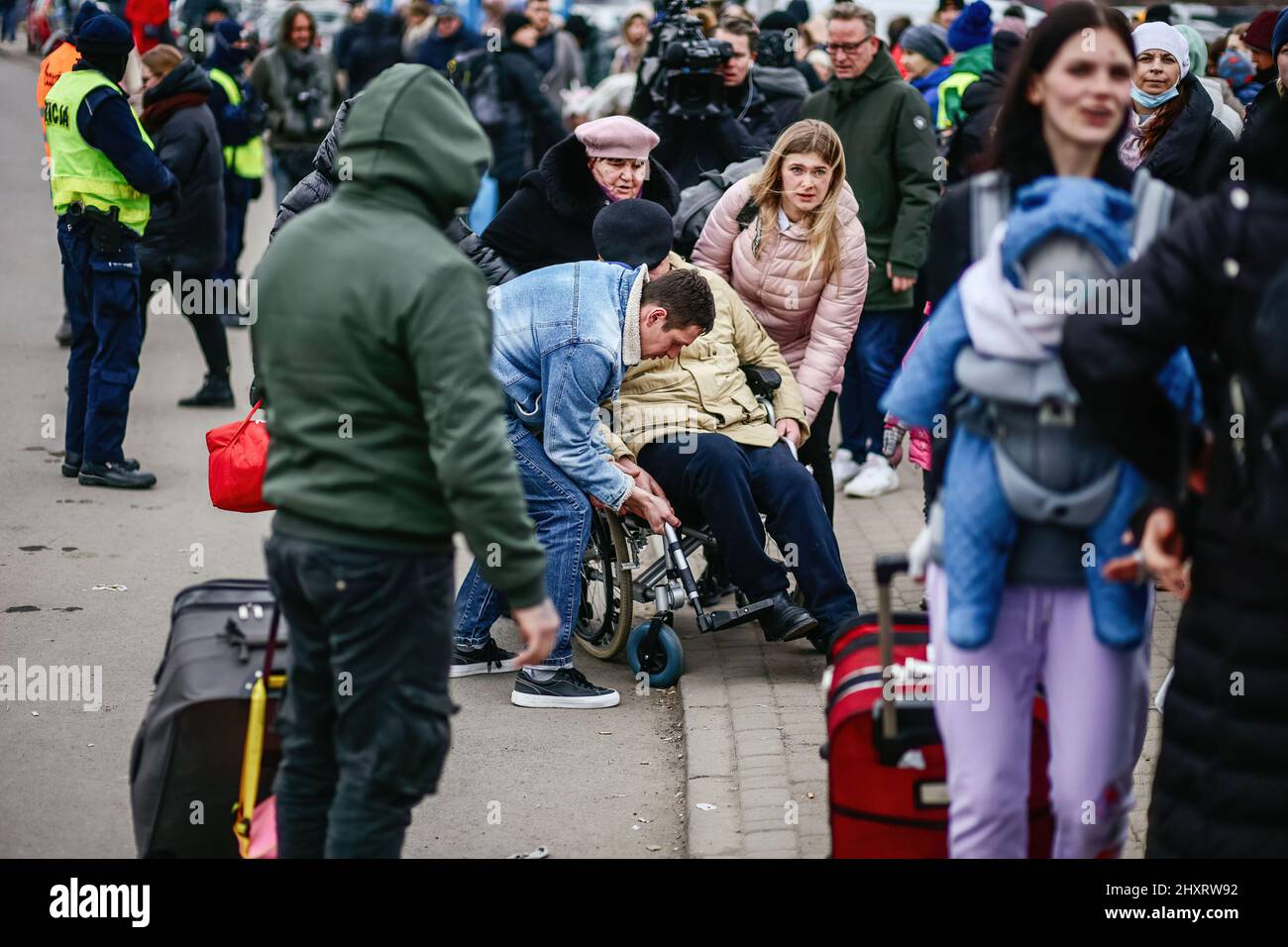 March 6, 2022, Medyka, Poland: Refugees seen carrying their disabled ...