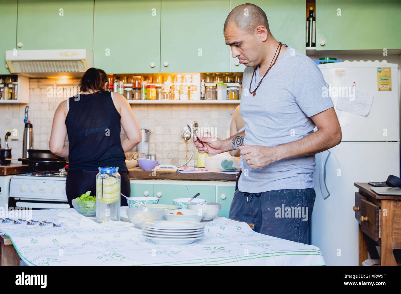 adult caucasian man in the kitchen at home standing by the table ...