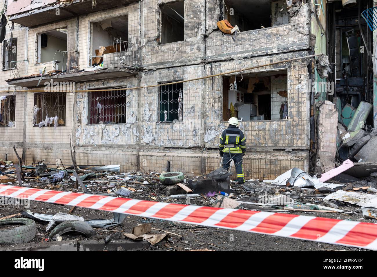 A firefighter seen inspecting the scene of a badly damaged residential ...
