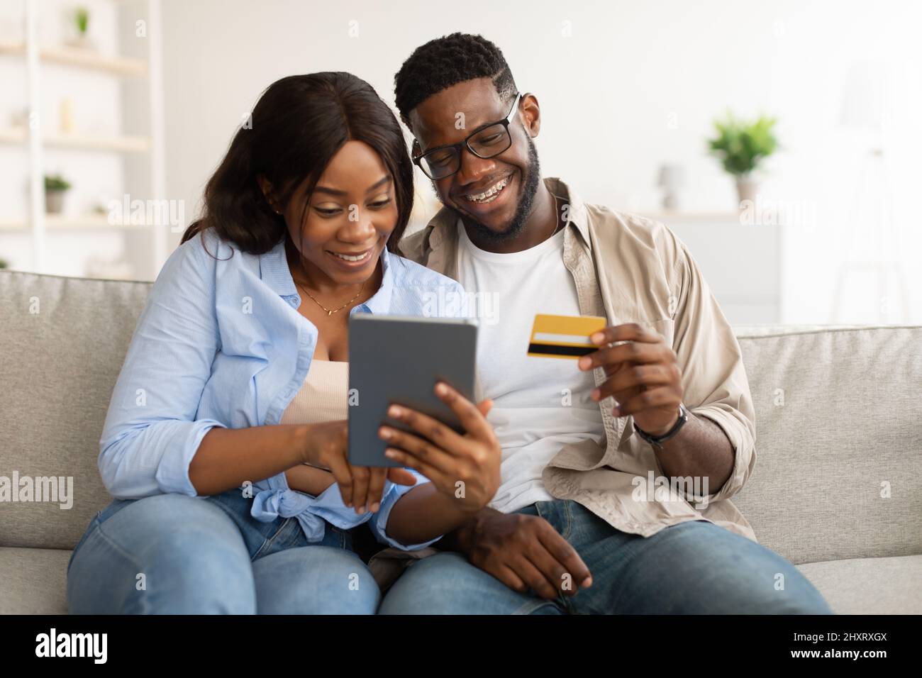 Black couple using tablet and debit credit card at home Stock Photo - Alamy