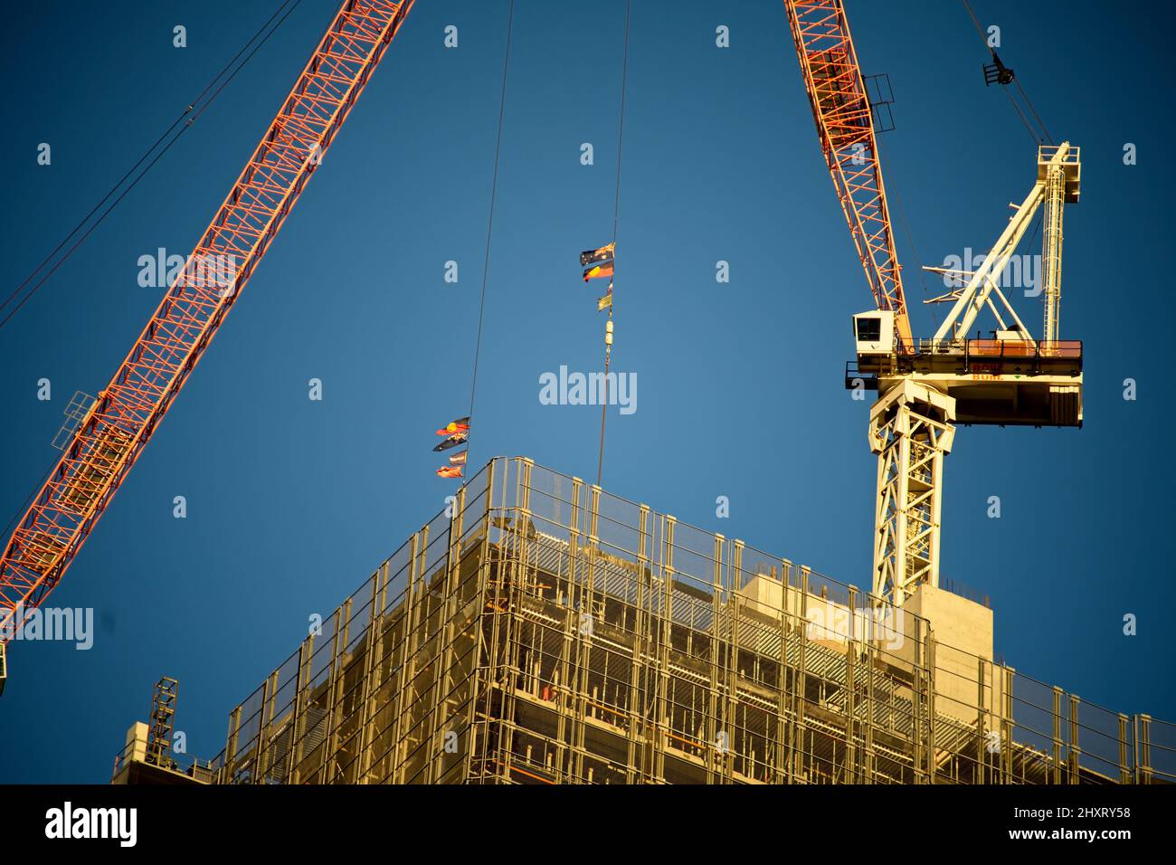 Low angle shot of a boom crane on an unfinished building with the clear ...