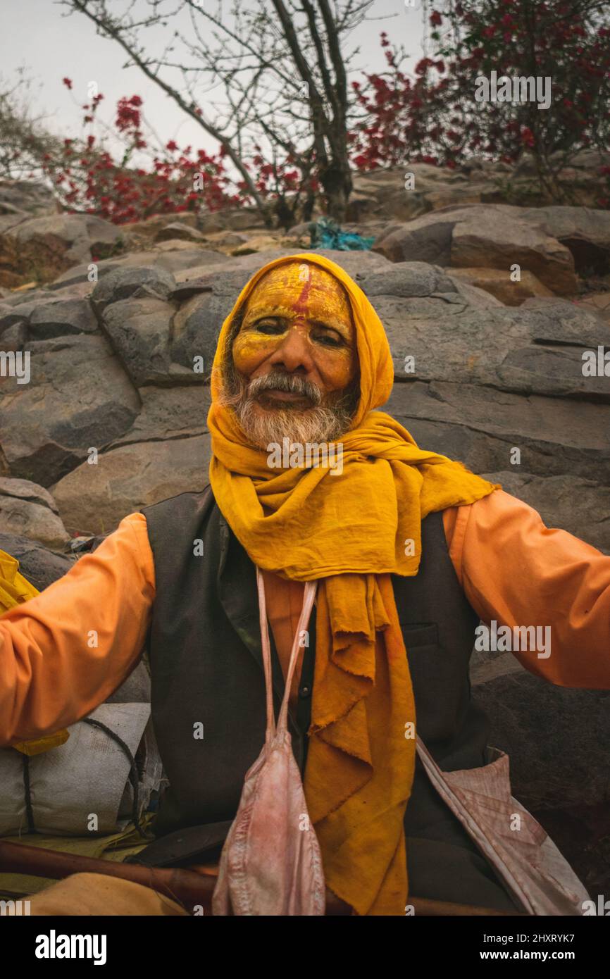 Religious ascetic Sadhu in traditional Indian clothes sitting outdoor ...