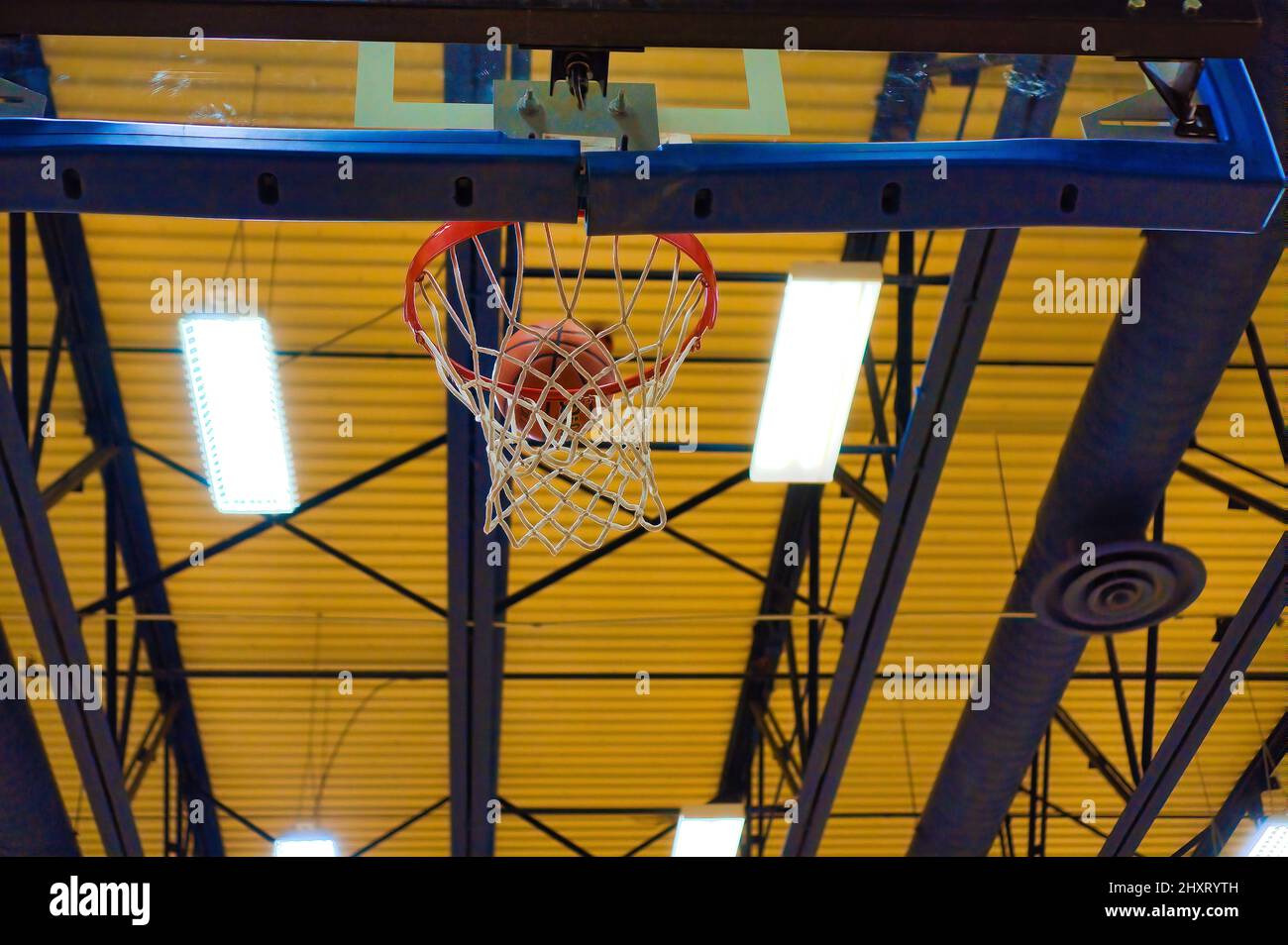 Low angle of a ball falling on the basketball netball and the yellow ...